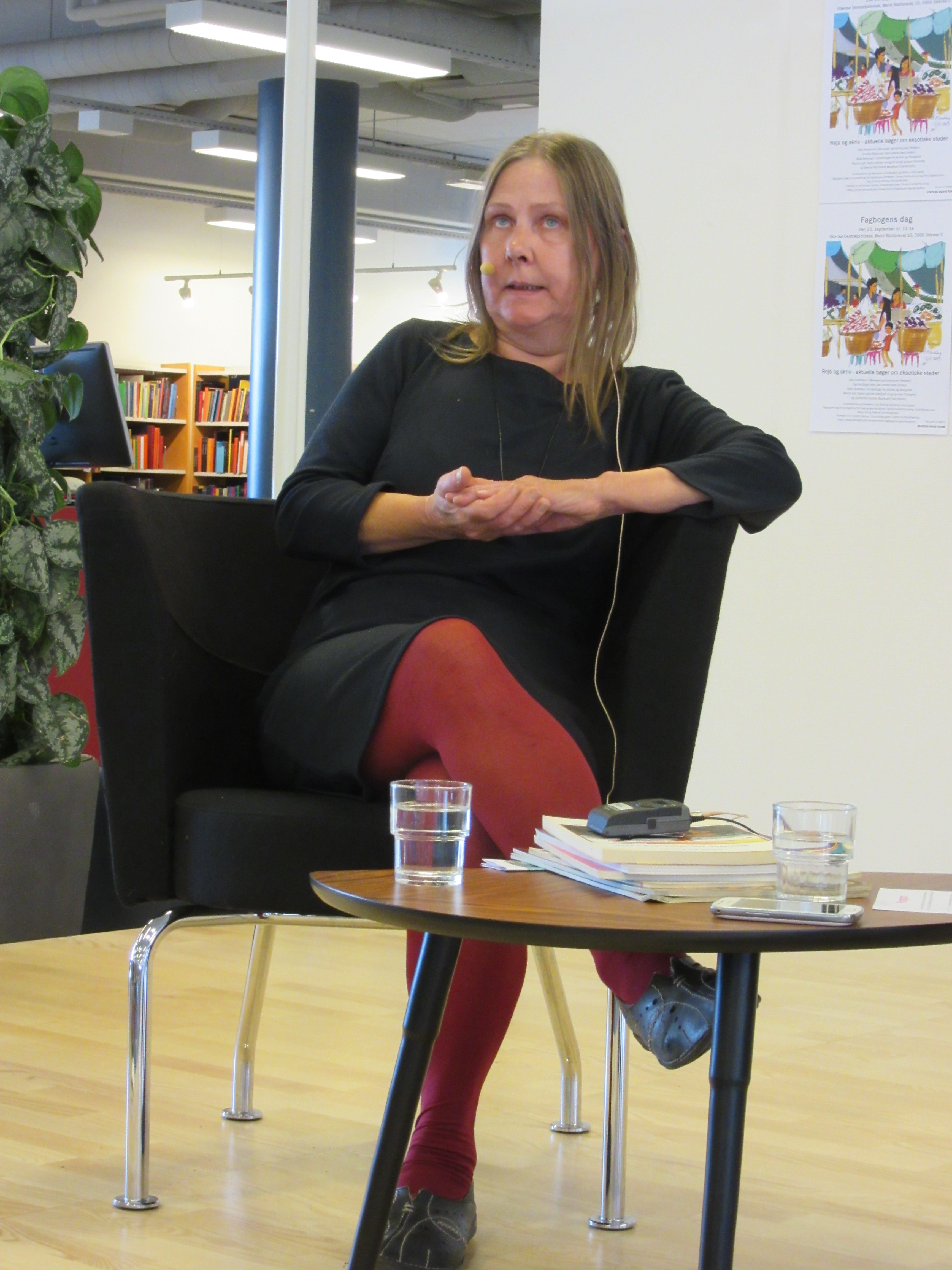 Gitte Pedersen tænker med plakater i baggrunden – ForlagetBostrup.dk